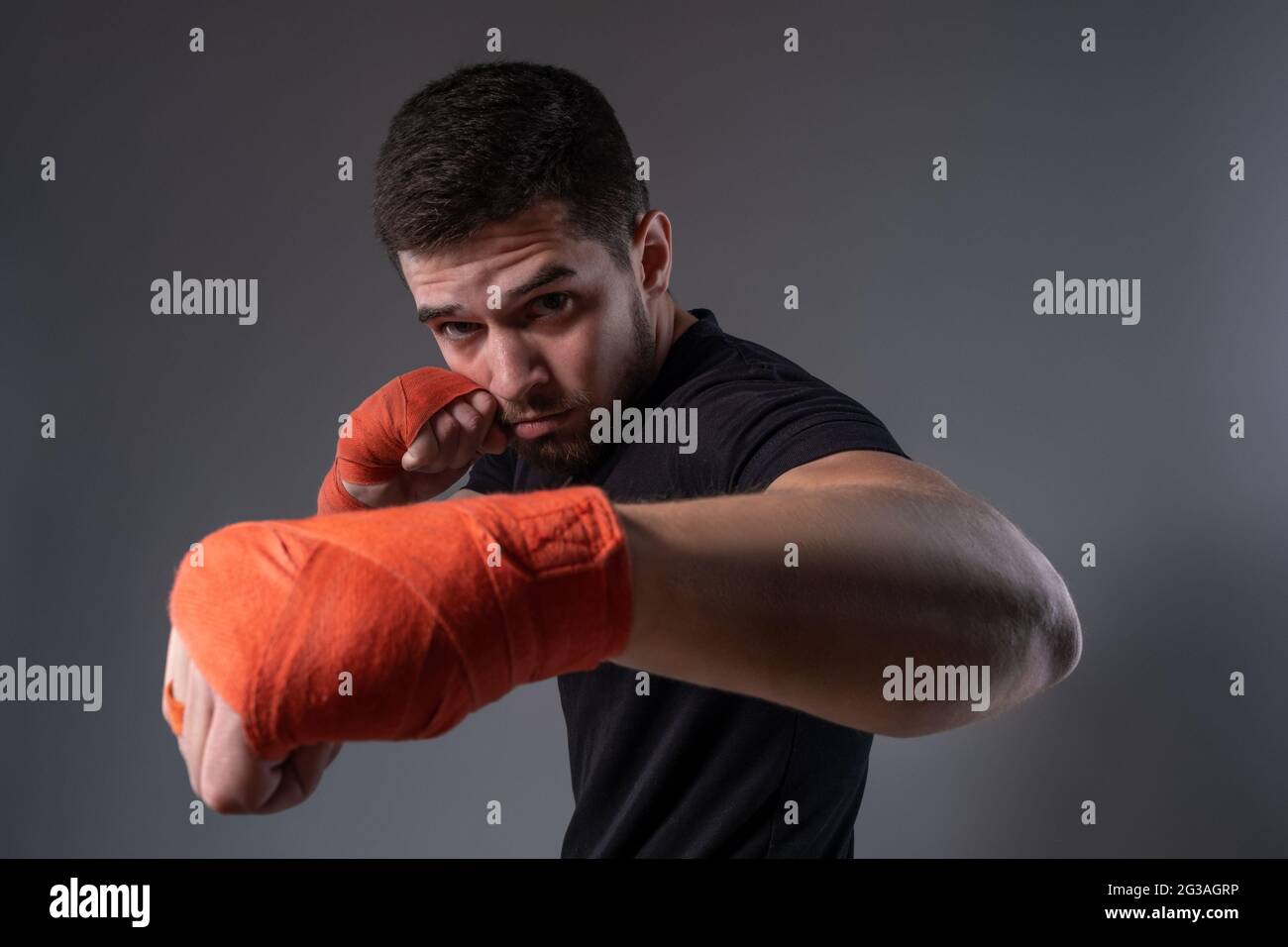 Young fighter performing left jab with hand wrapped in boxing tape ...