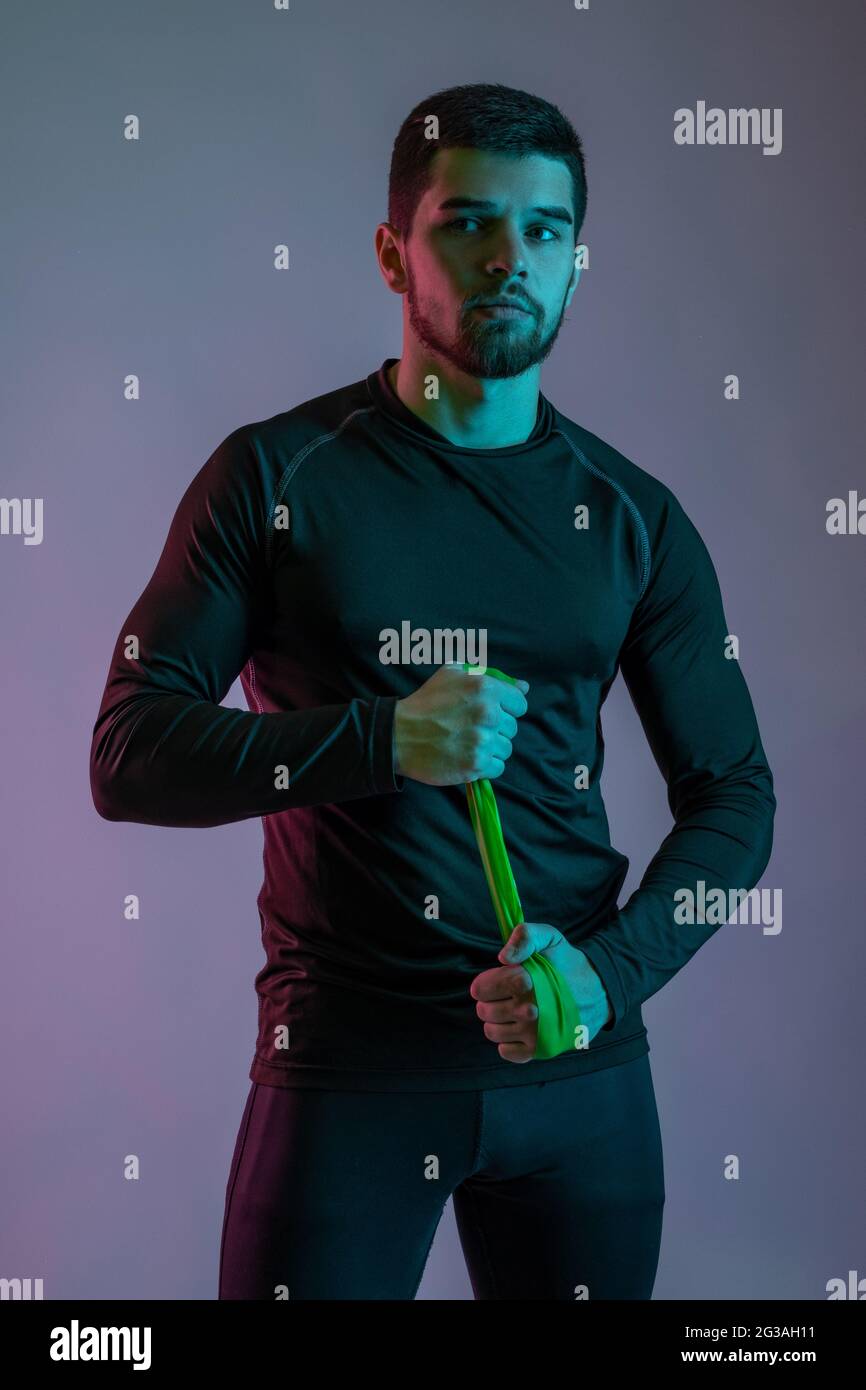 Athletic guy posing with resistance band in hands Stock Photo - Alamy