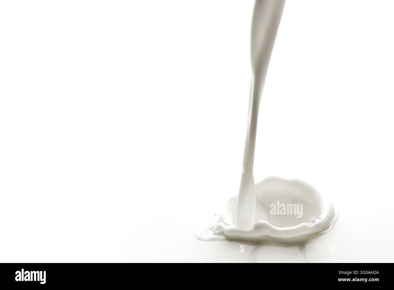 Pouring milk splash isolated on white background macro Stock Photo - Alamy