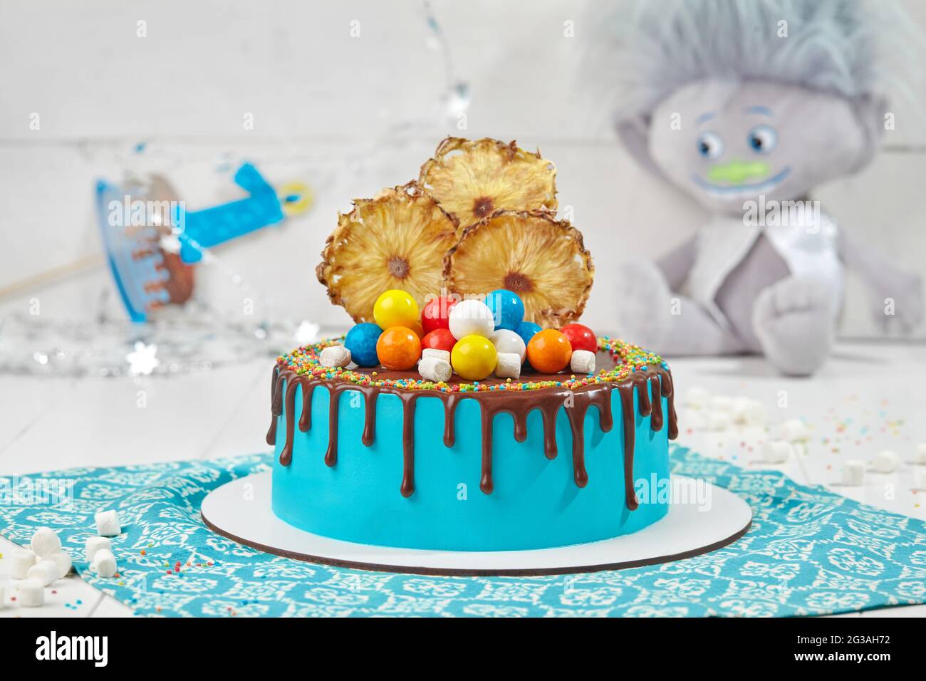 Blue cake with chocolate icing, candied pineapple, colorful balls of ...