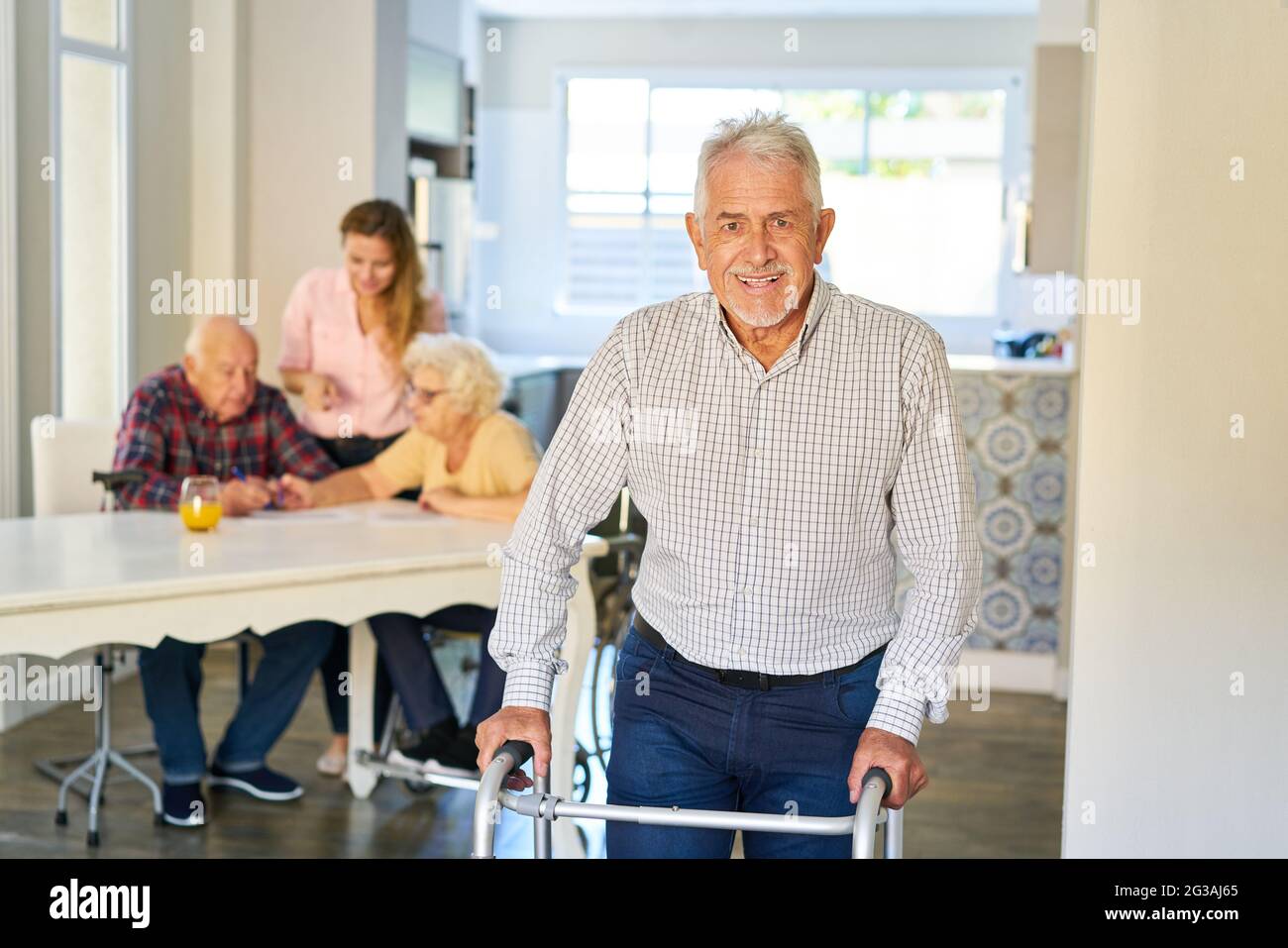 Satisfied senior after stroke with walking aid or rollator in a nursing ...