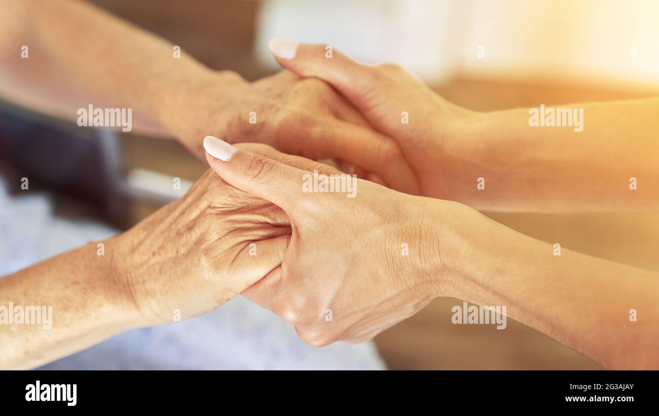Seniors holding hands for consolation and sympathy in the event of ...