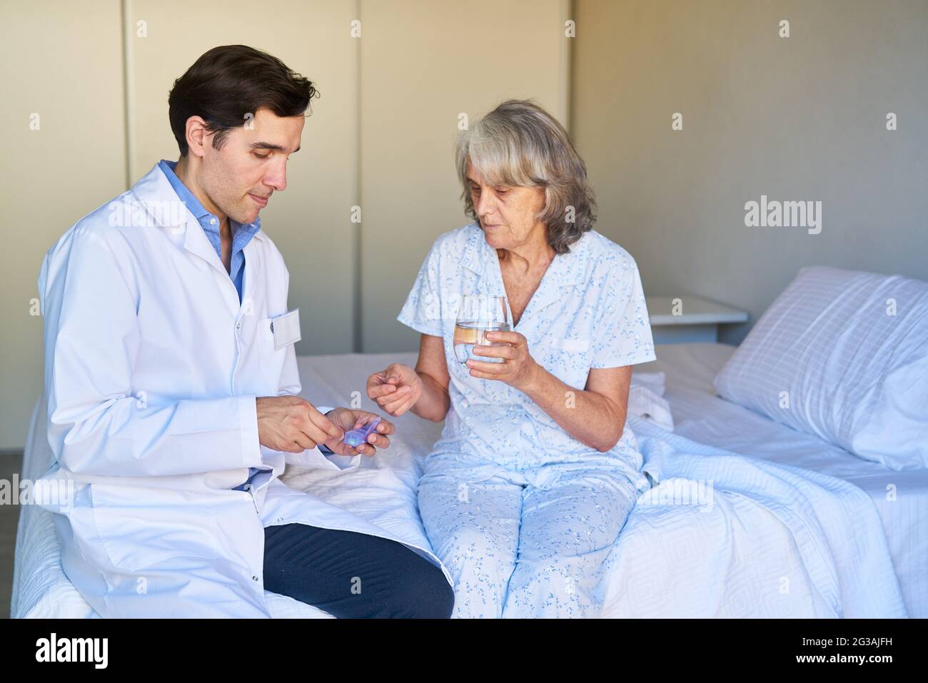 Geriatric nurse giving medication to a senior citizen in a nursing home ...