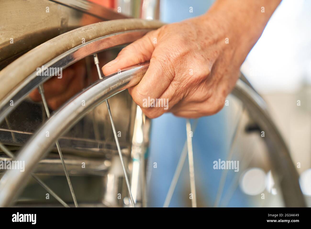Hand of a patient on the tire of a wheelchair as a symbol for ...