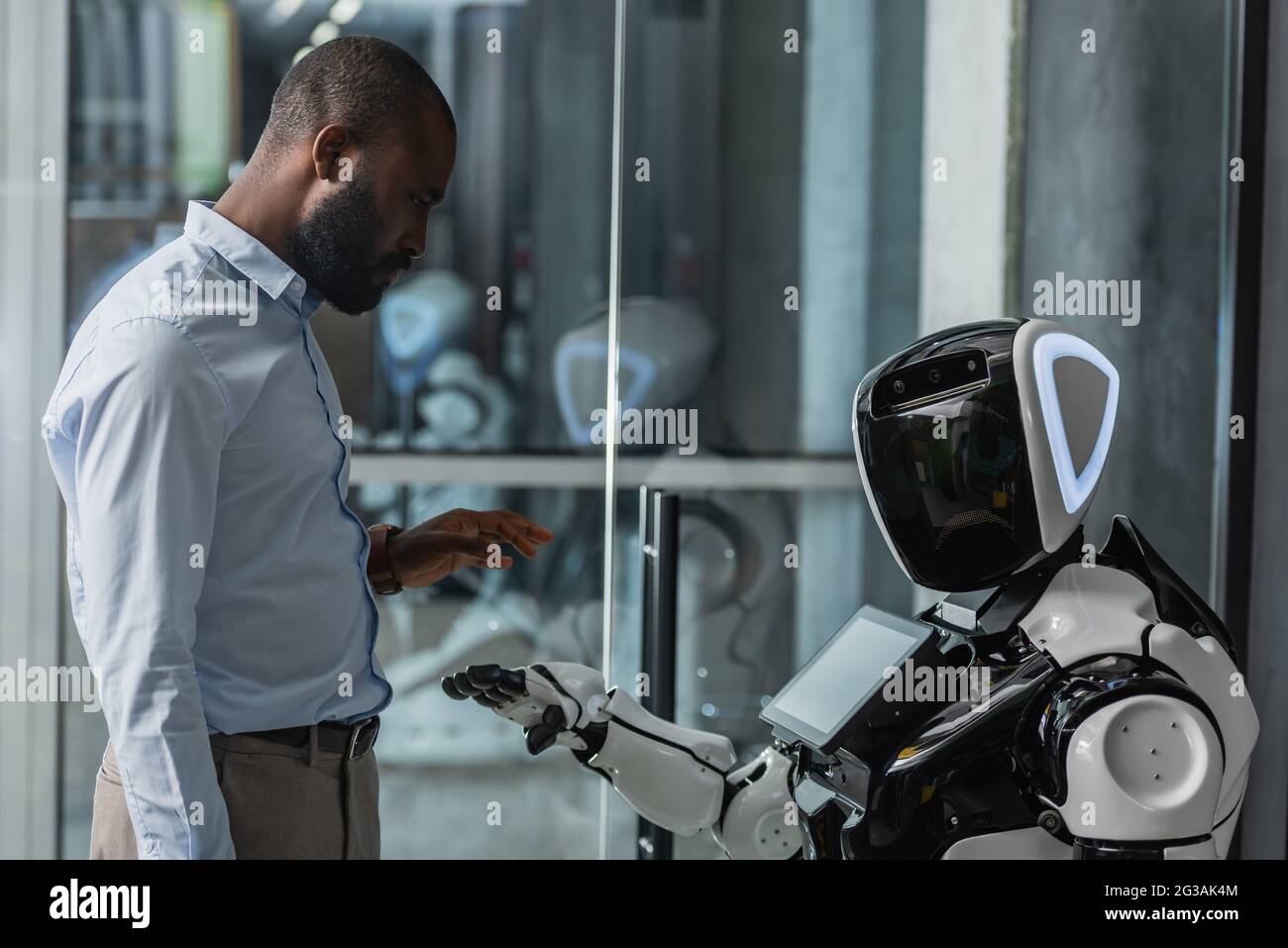 african american businessman standing near humanoid robot in office ...