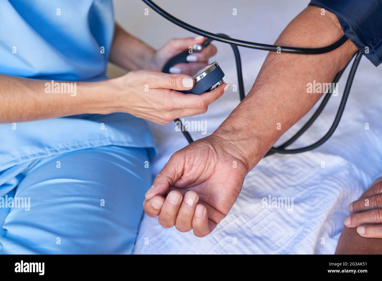 Hands of patient and carer while measuring blood pressure with a blood ...