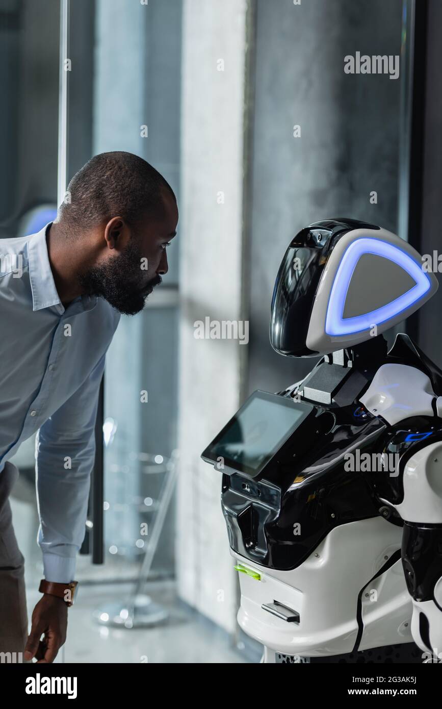 african american businessman looking at robot in office Stock Photo - Alamy