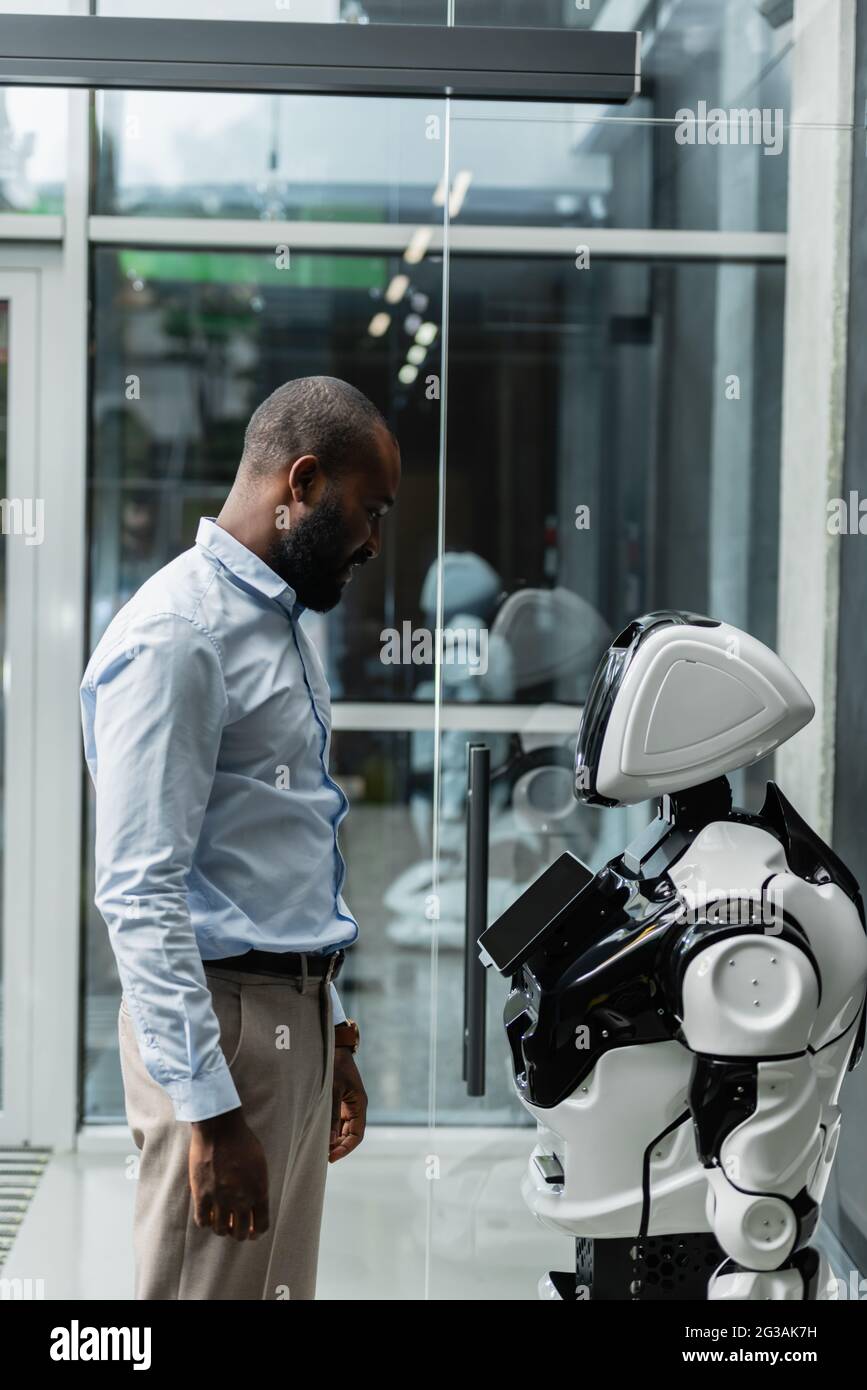 african american engineer looking at humanoid robot in office Stock ...