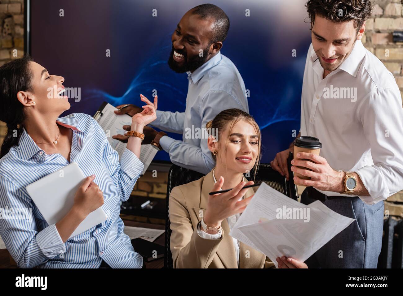 excited multiethnic business people talking during meeting in ...
