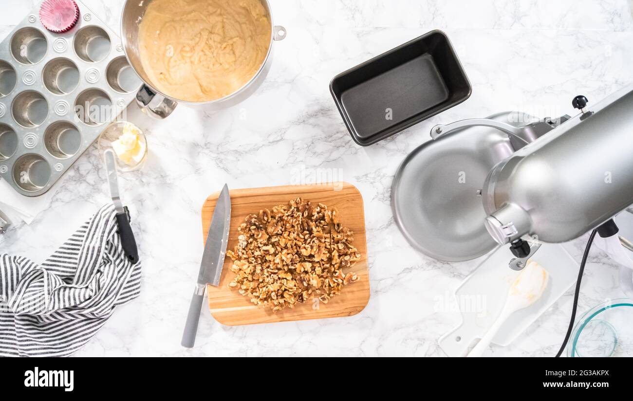 Flat lay. Chopping walnuts into small pieces with kitchen knife on a ...