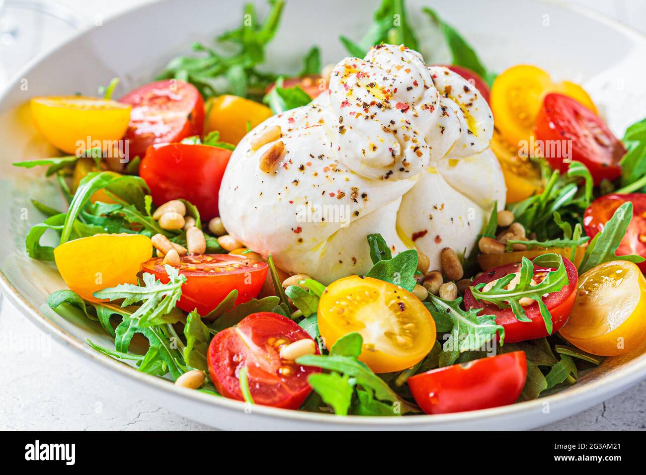 Burrata cheese salad with arugula and tomatoes. Italian cuisine concept ...