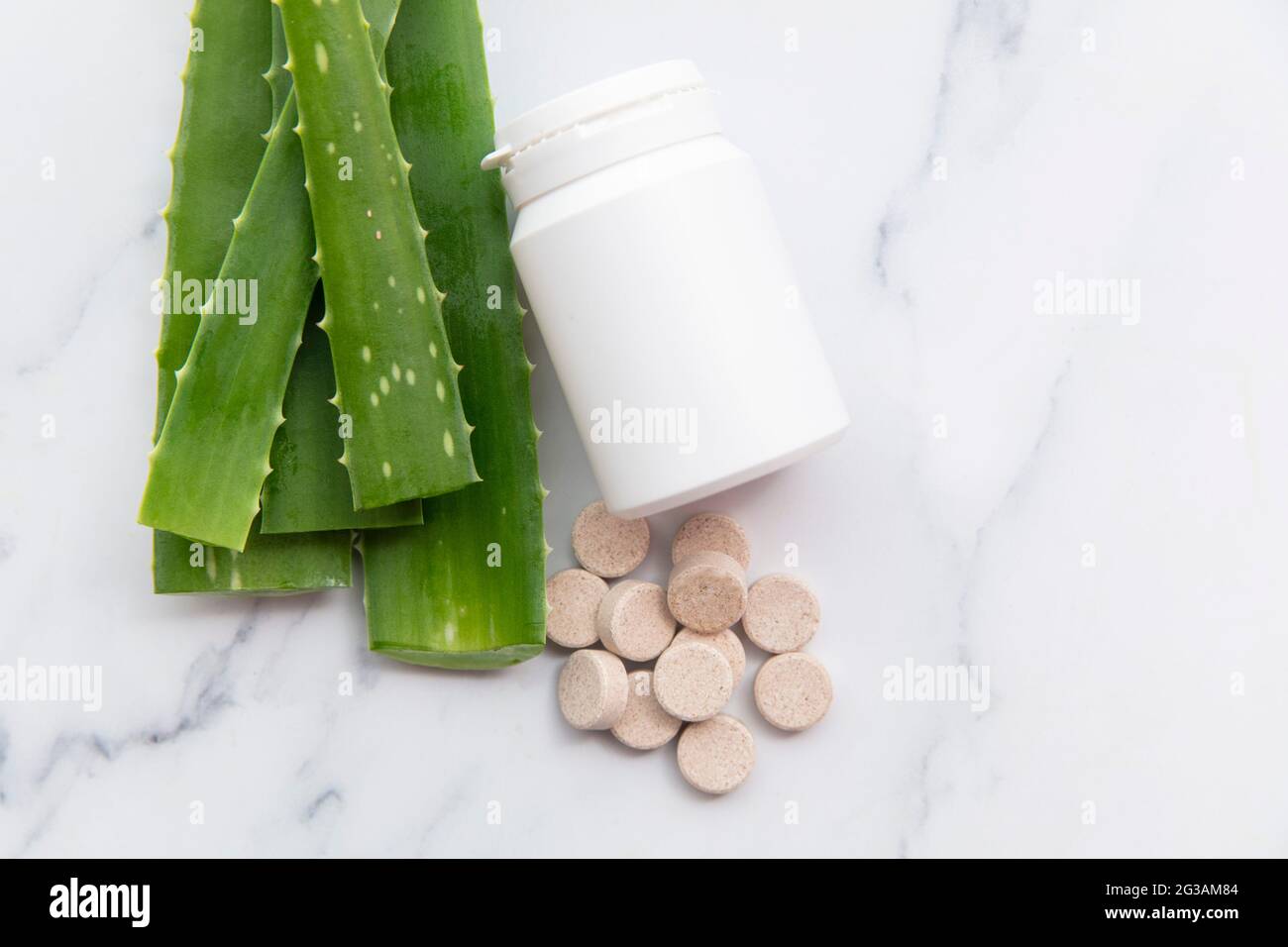 Aloe vera natural tablets. Freshly cut leaves with a pill bottle and ...