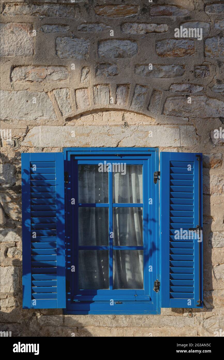 A gray building with blue window frames in the Greek style. Travel and ...