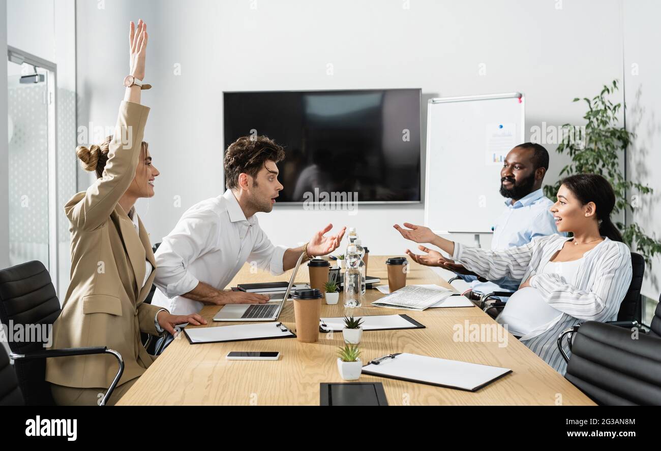 excited multiethnic business people gesturing during discussion in ...