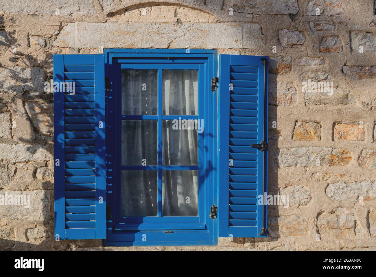 A gray building with blue window frames in the Greek style. Travel and ...