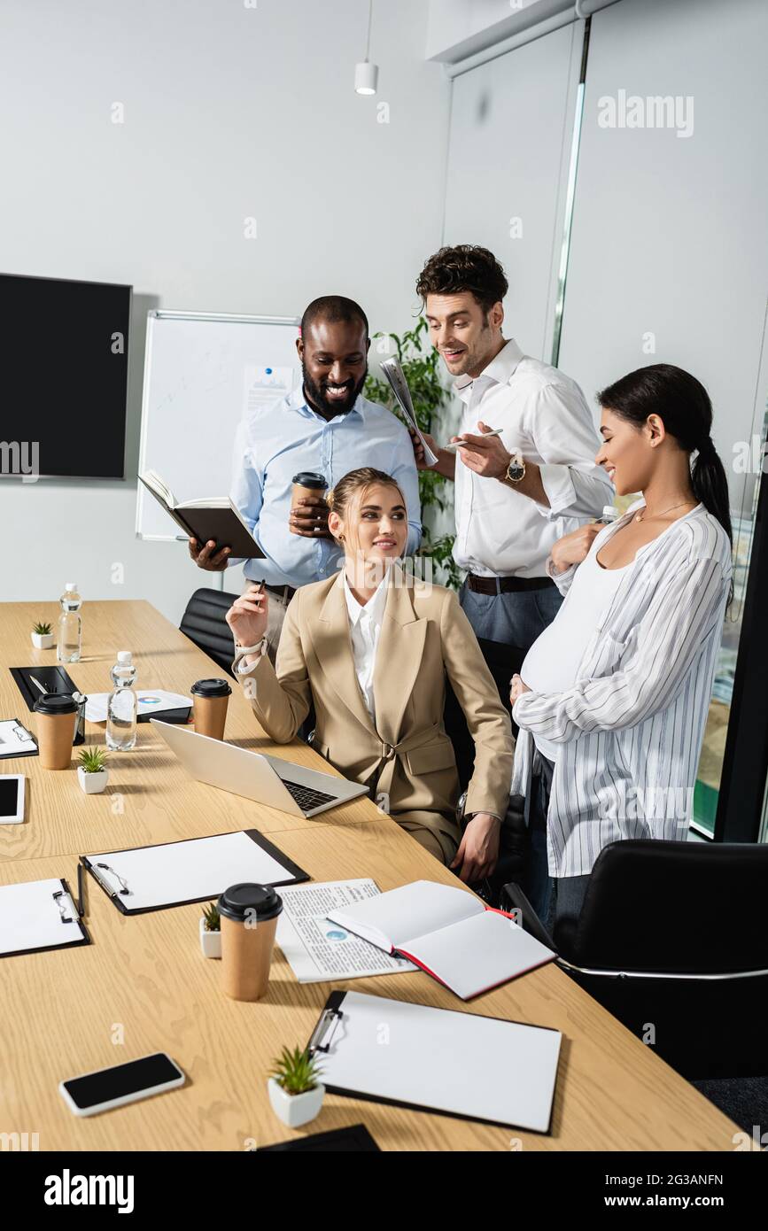 cheerful business partners talking during meeting in conference room ...