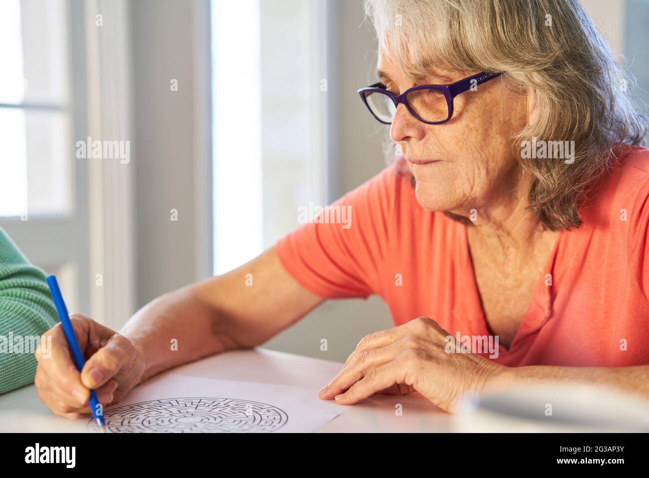 Senior woman with dementia solves maze puzzles as memory training and ...