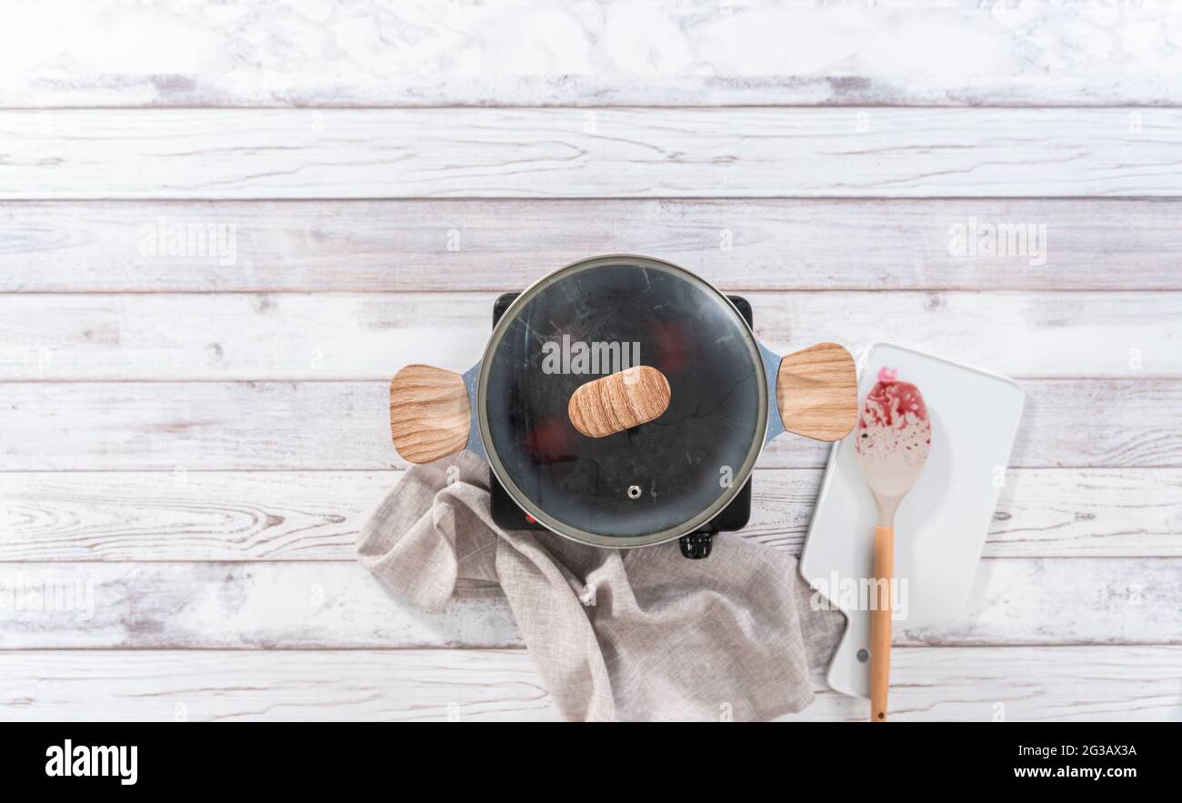 Flat lay. Preparing mixed berry compote from frozen berries in a ...