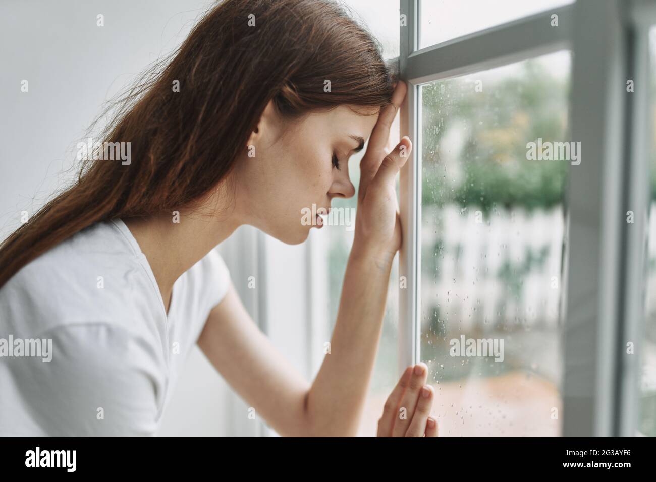 sad woman leaning on the glass window and sad face model room Stock ...