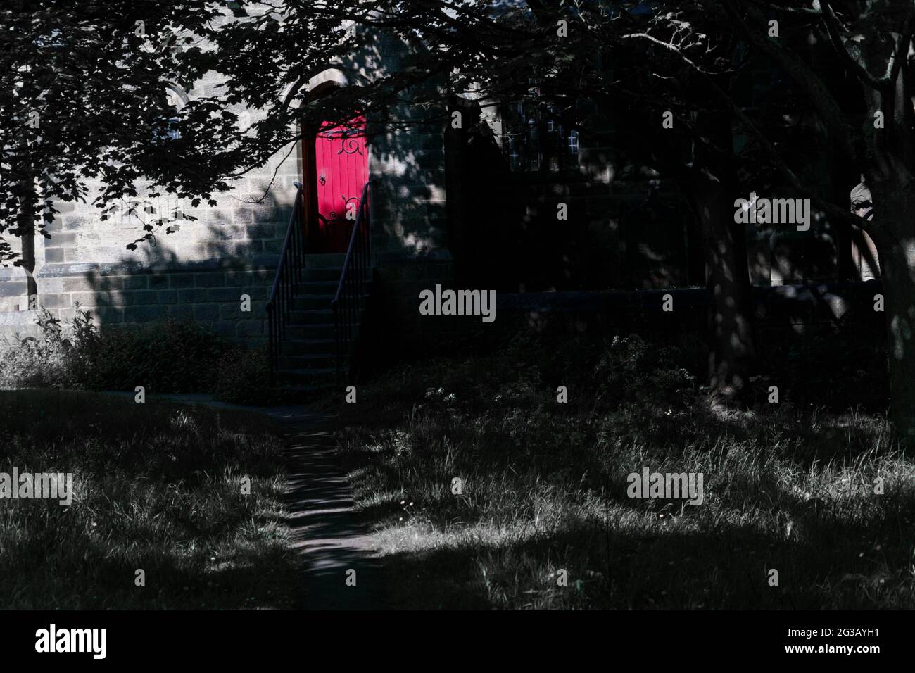 A small vaulted side door made of pink wood stands at the end of a ...