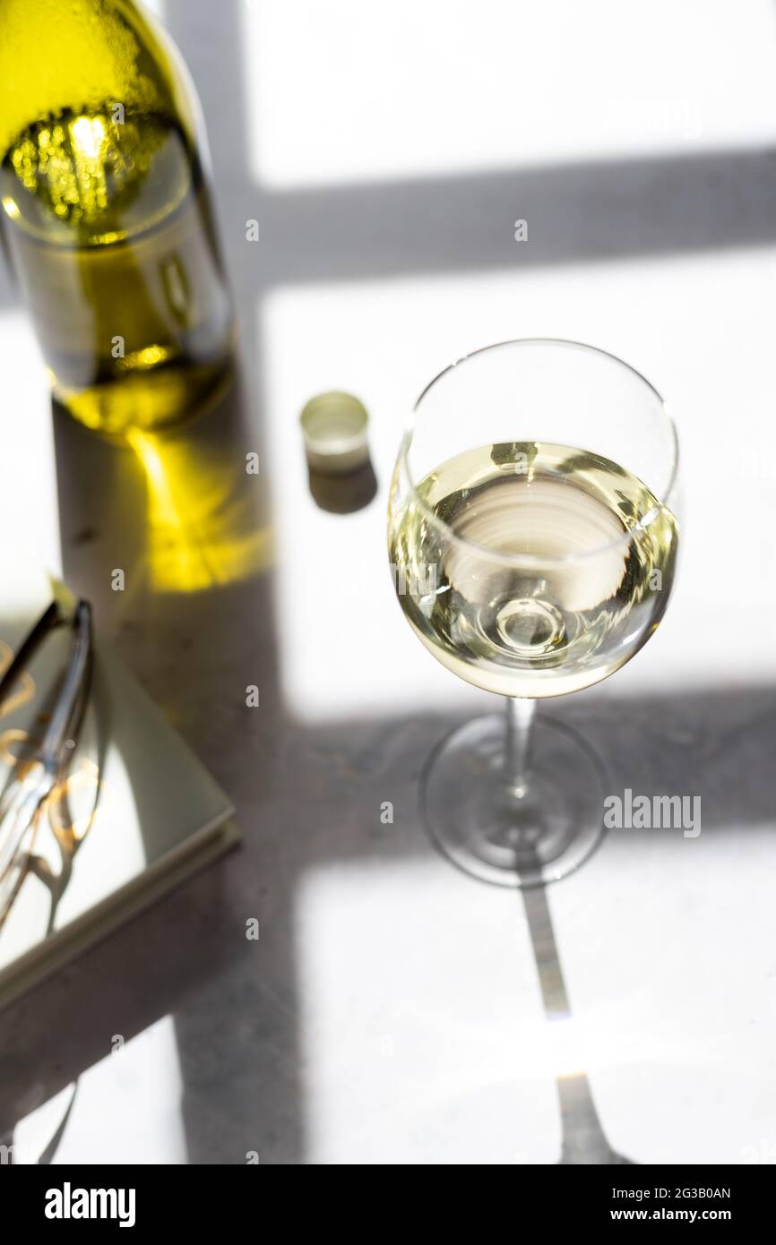 A glass of white wine by a window in the sunshine Stock Photo - Alamy