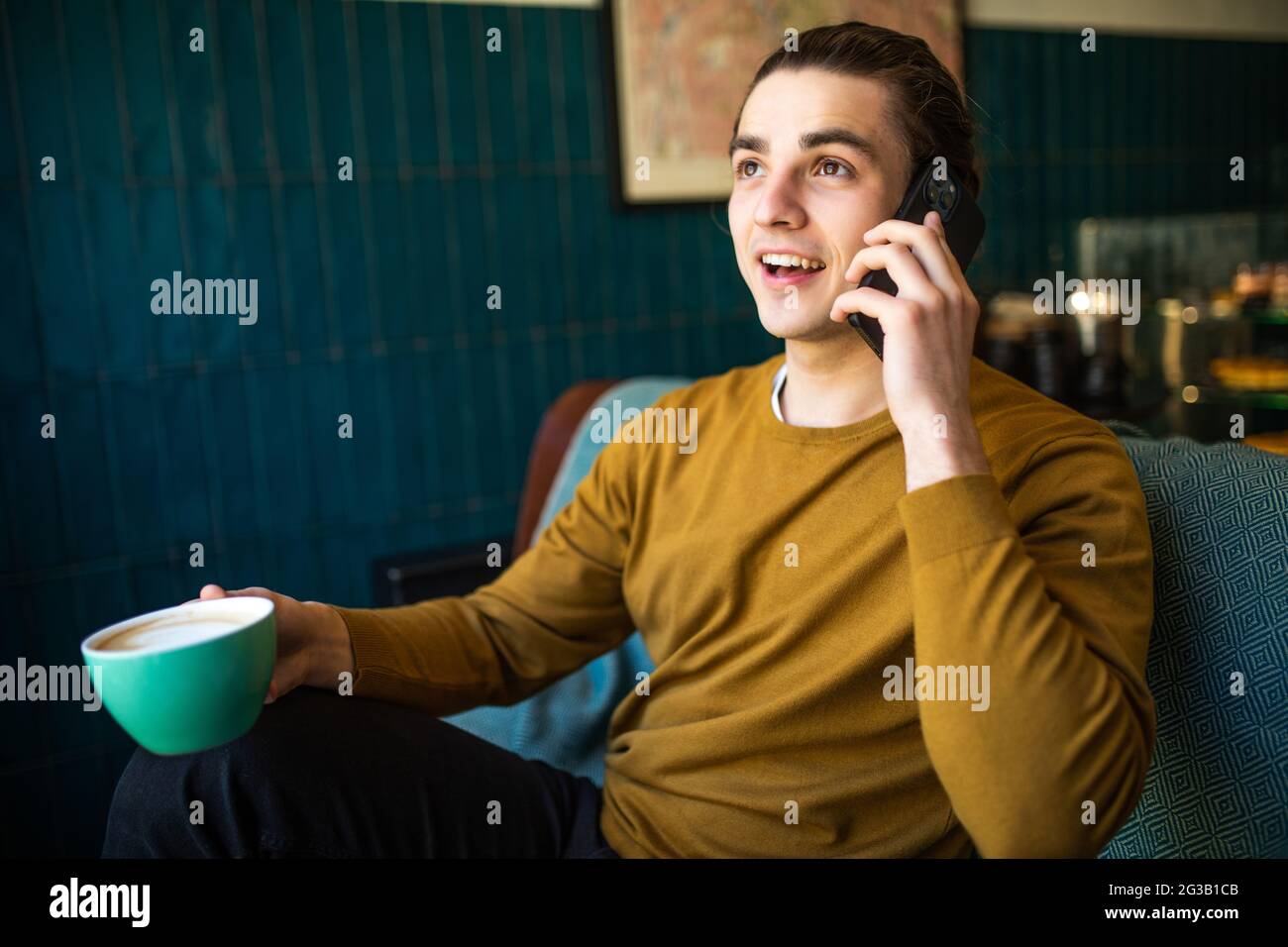 Happy man at coffee shop talking on the phone Stock Photo - Alamy