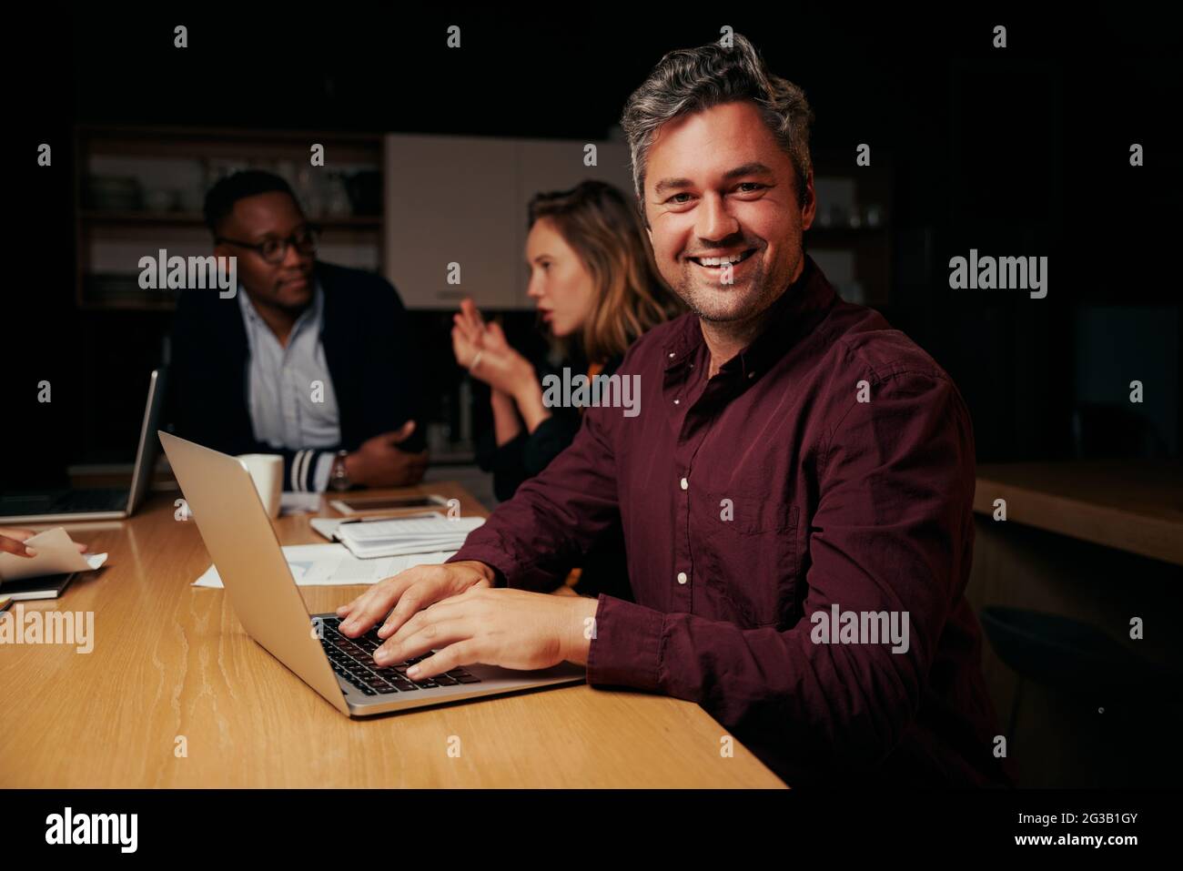 Portrait of a successful male business leader using laptop with his ...