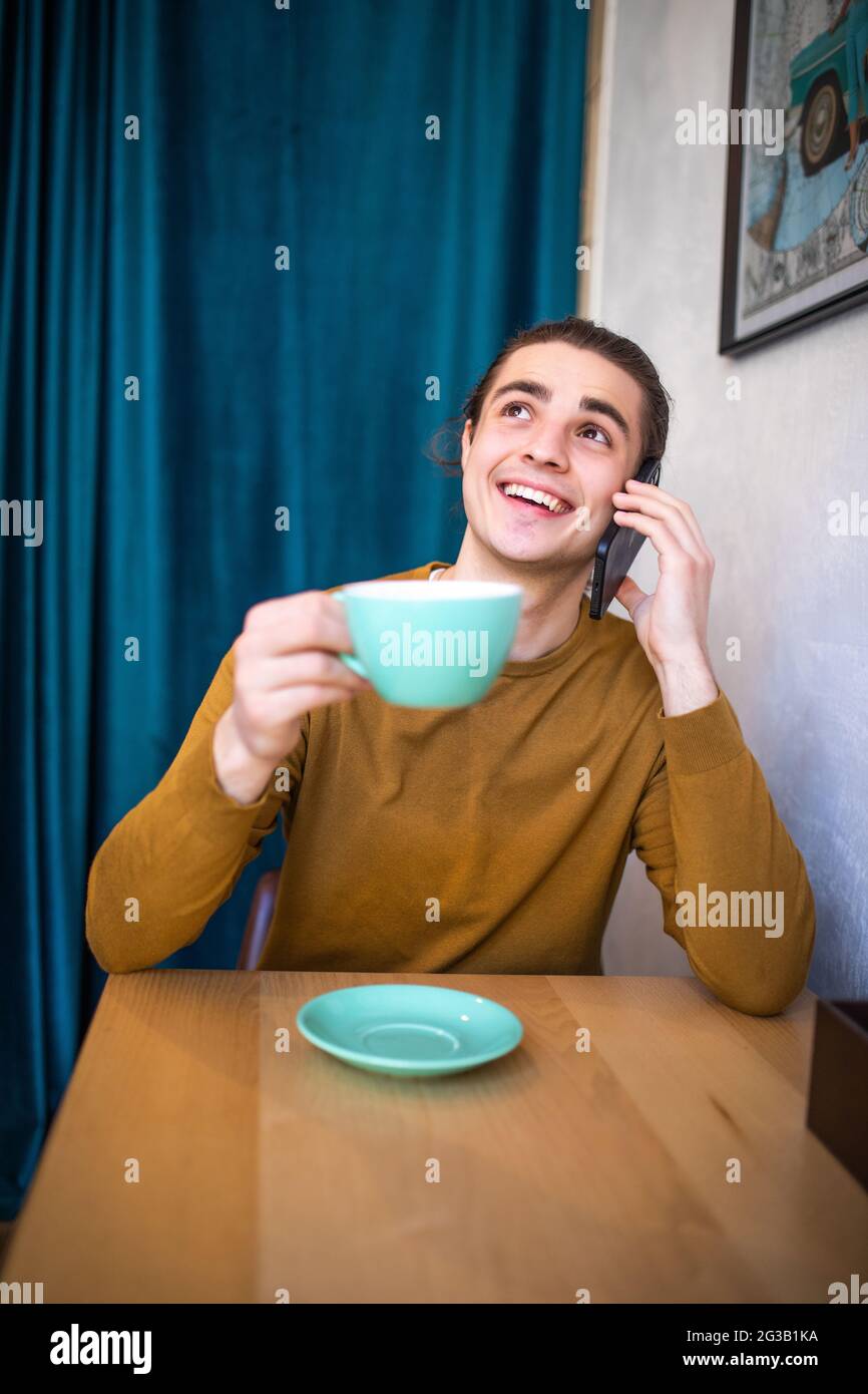 Happy man at coffee shop talking on the phone Stock Photo - Alamy