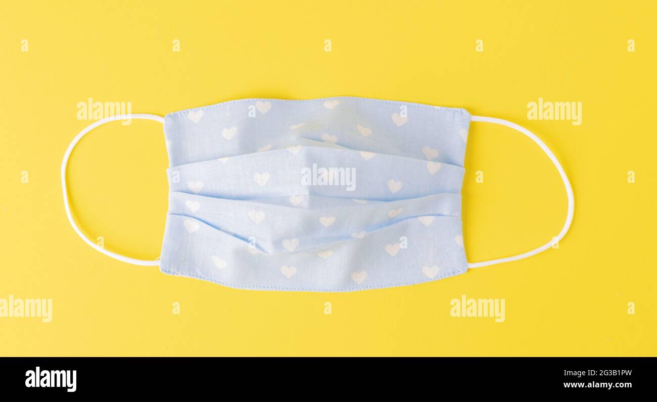 Eco-friendly reusable cloth protective mask yellow background. Homemade ...