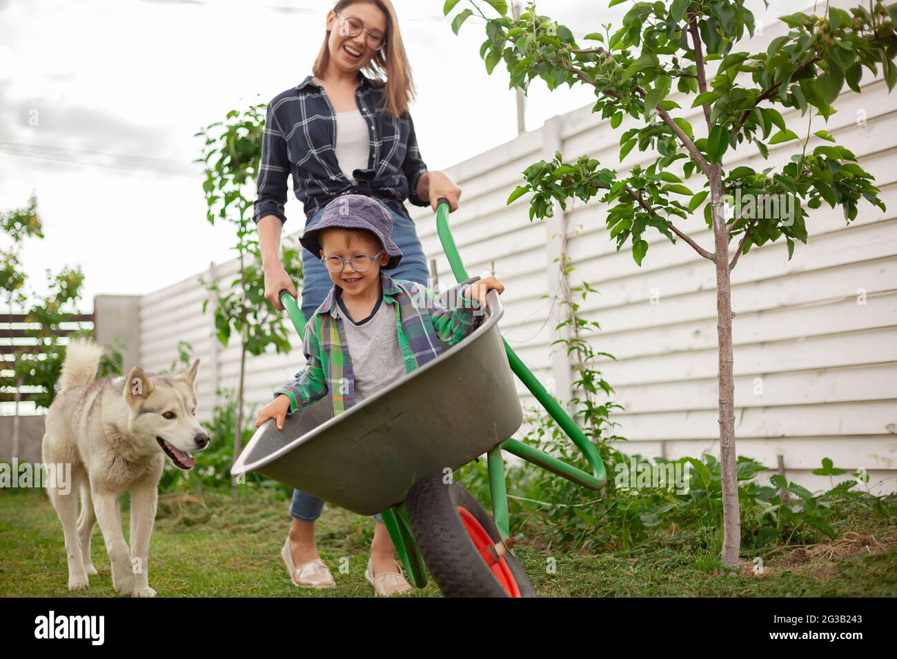 Mother and child ride a garden cart having fun in backyard garden Stock ...