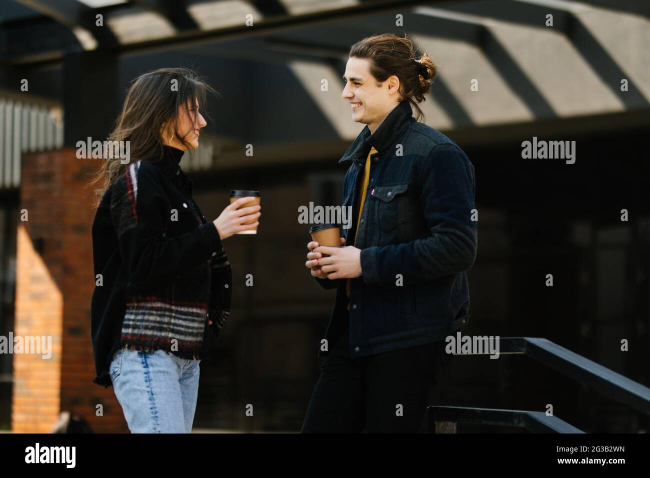 Pretty couple drinking coffee on the street cafe having fun together ...