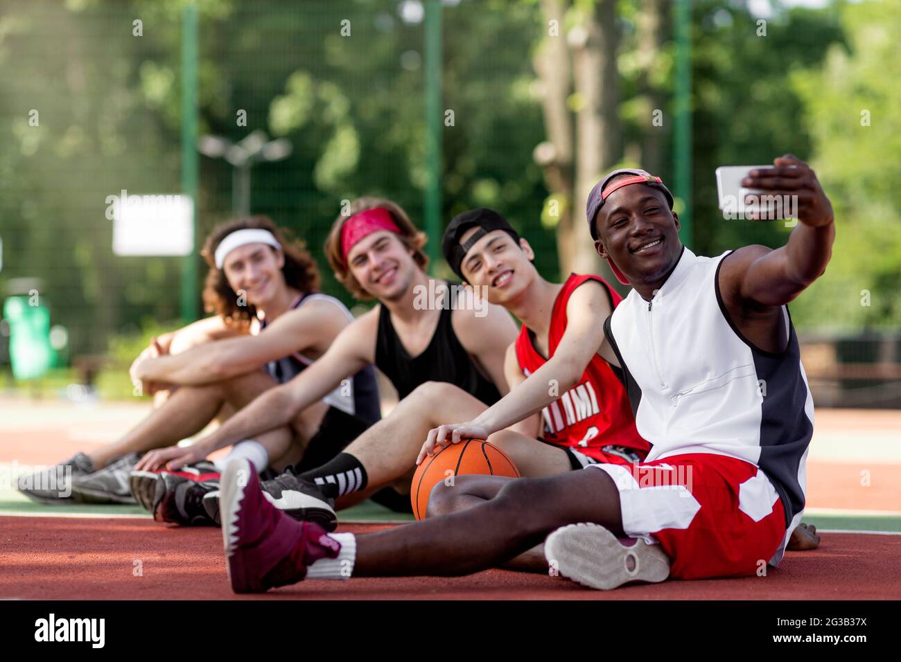 Team of happy basketball players taking selfie while relaxing after ...