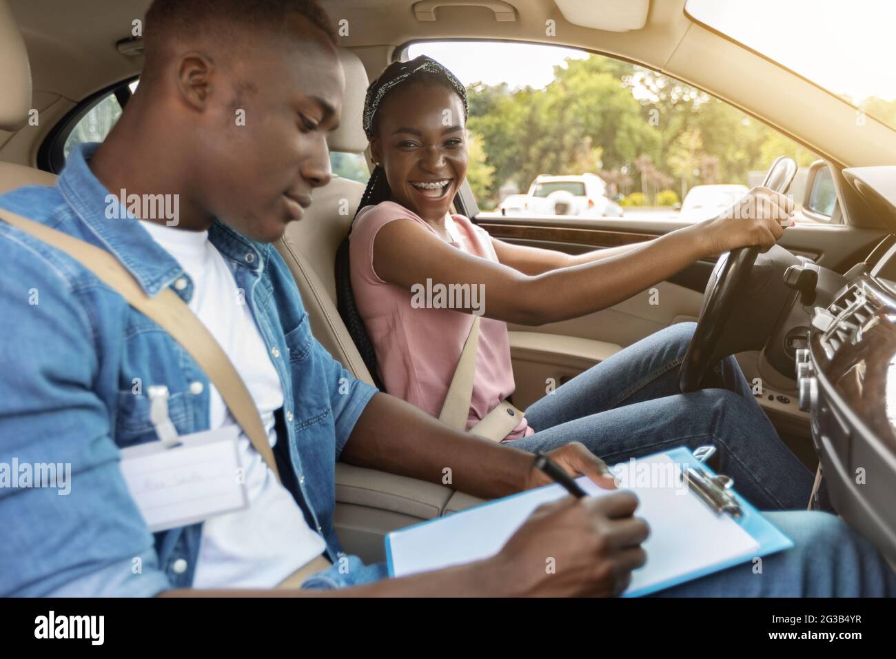 Young black man instructor examinating happy lady student, taking notes ...