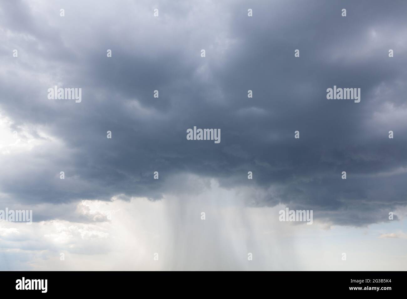 Cloudburst with a sudden heavy rainfall . Dark clouds with torrential ...