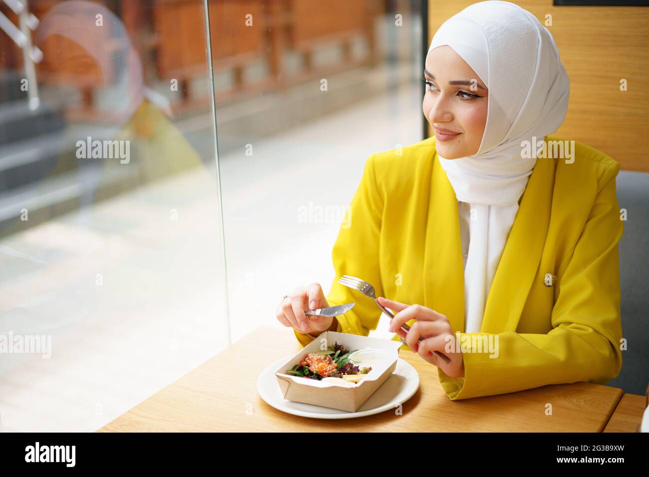 Woman eating table head scarf hi-res stock photography and images - Alamy