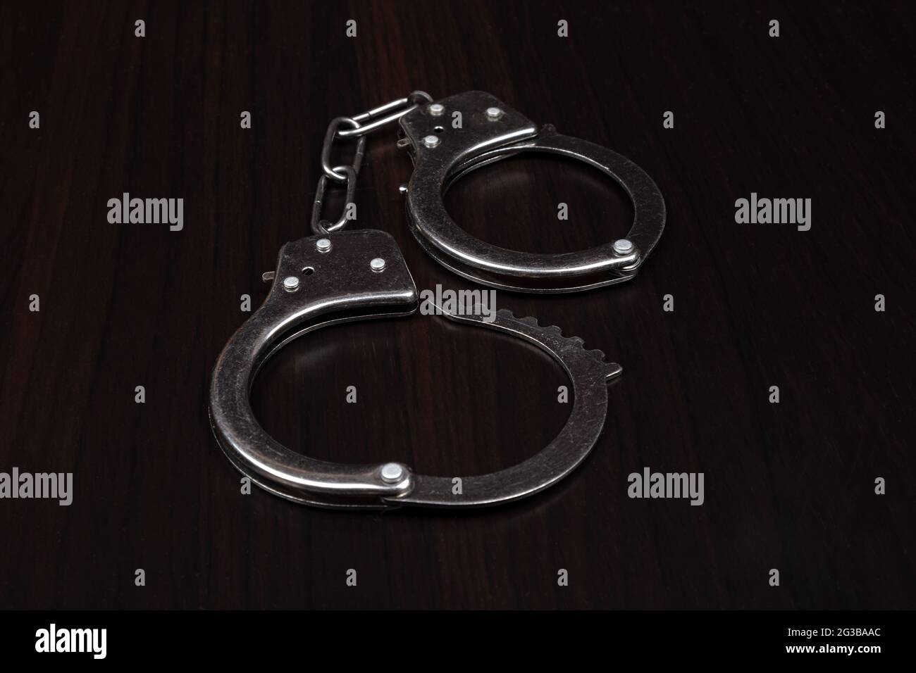 handcuffs on a dark background closeup Stock Photo - Alamy