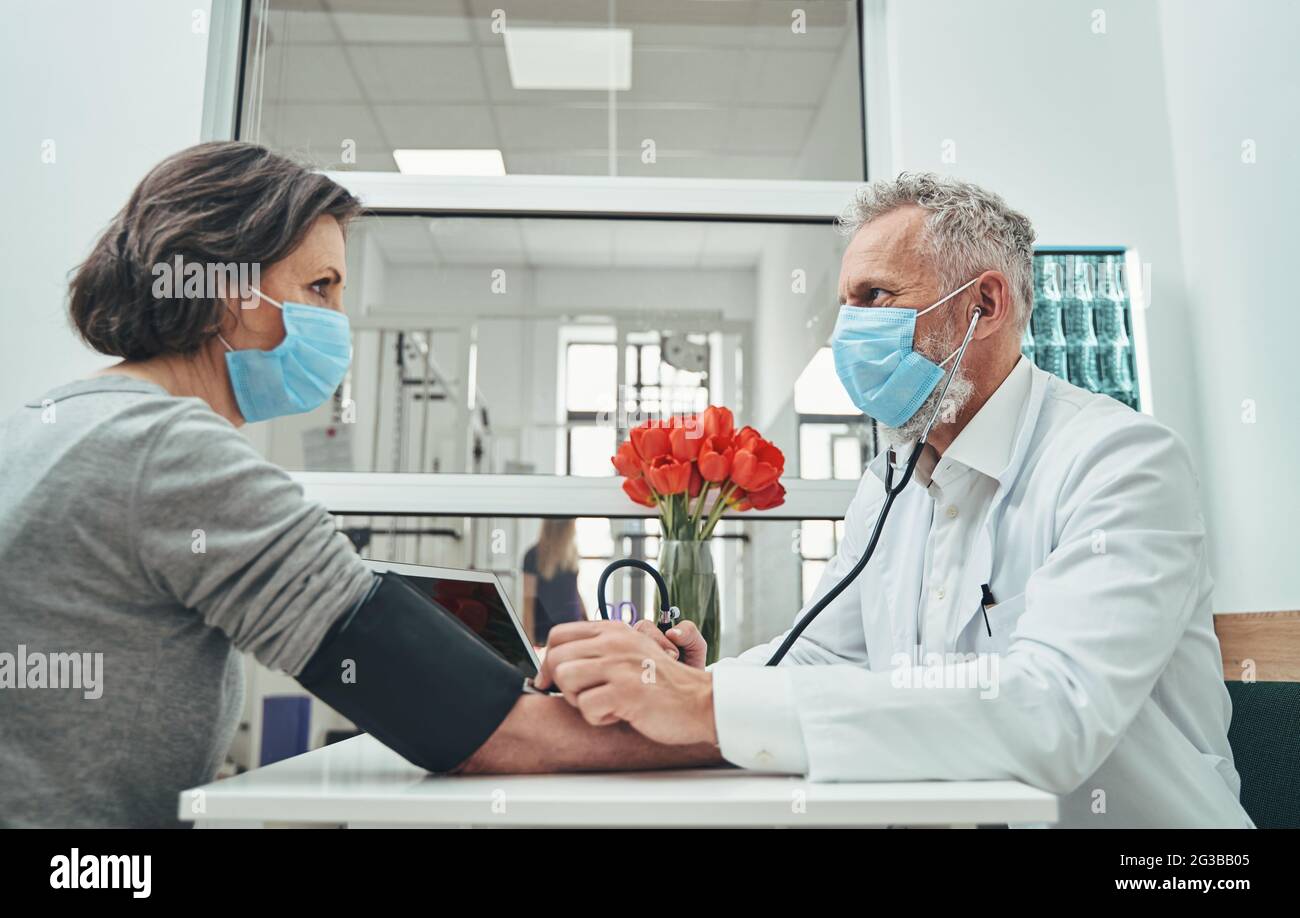 Mature woman in a face mask undergoing a routine medical check-up Stock ...