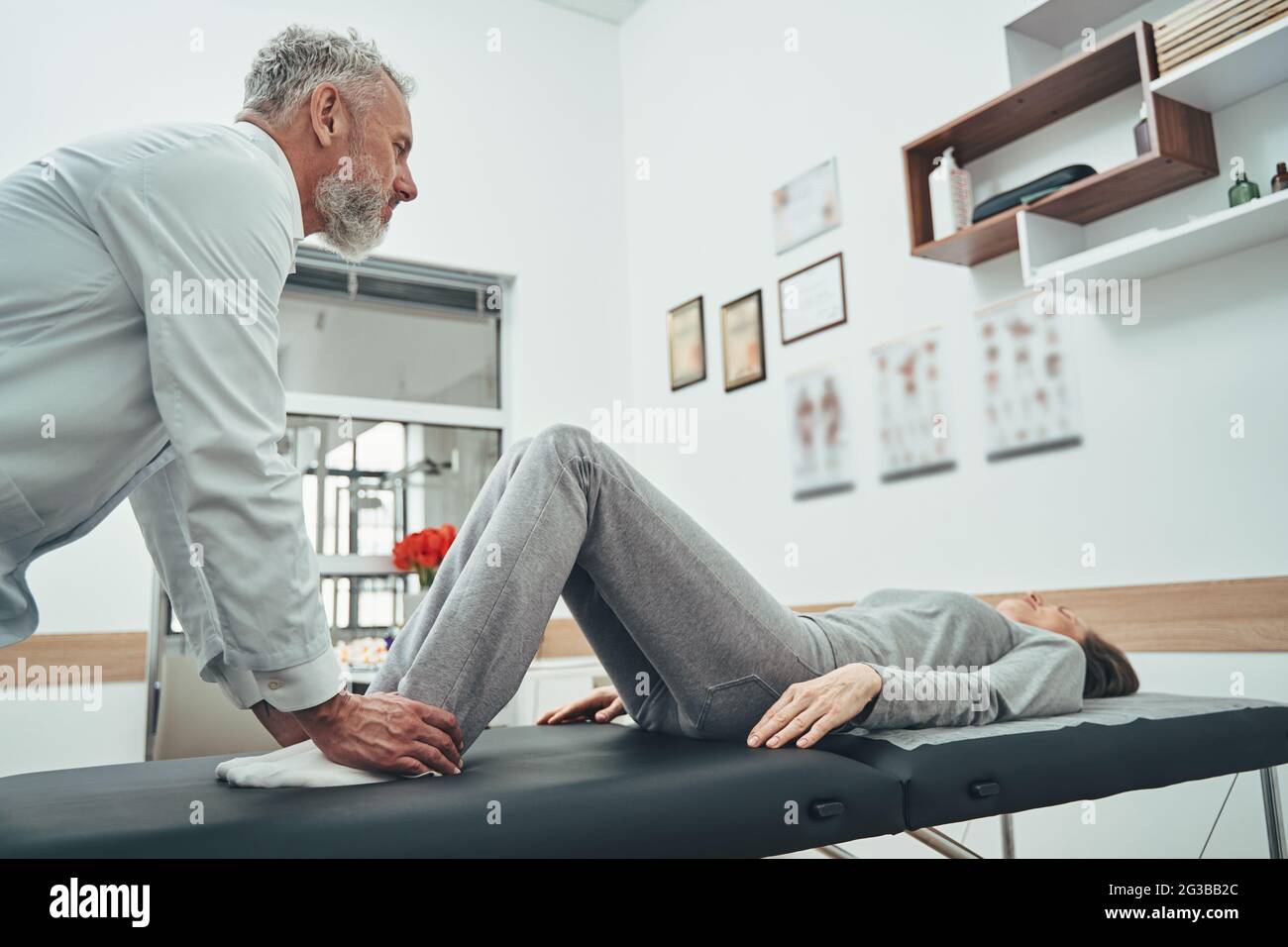 Qualified doctor conducting a manual muscle strength test Stock Photo ...