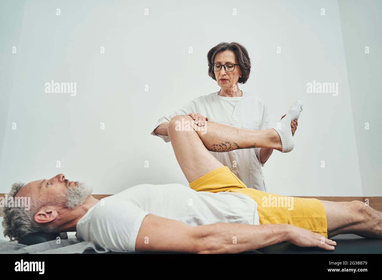 Medical specialist doing a passive hip rotation test Stock Photo - Alamy