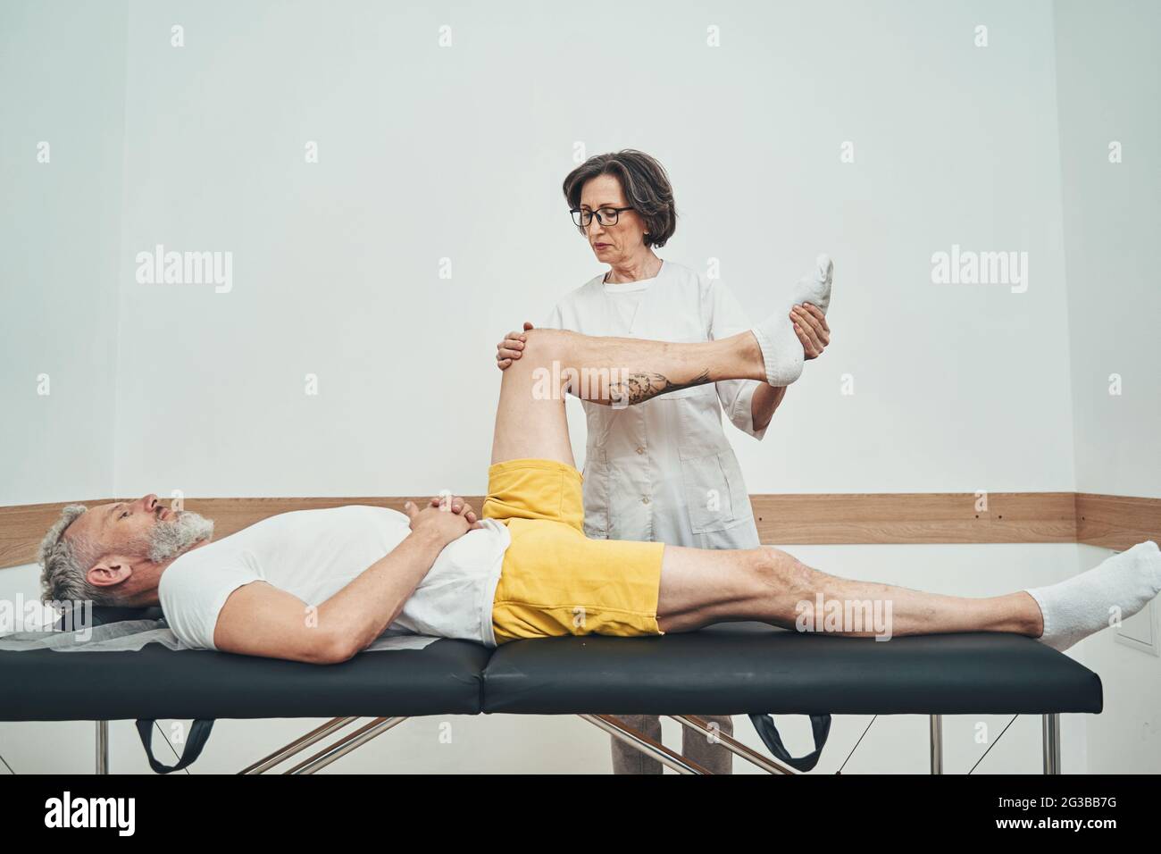 Lady doctor performing a hip joint resisted isometric test Stock Photo ...
