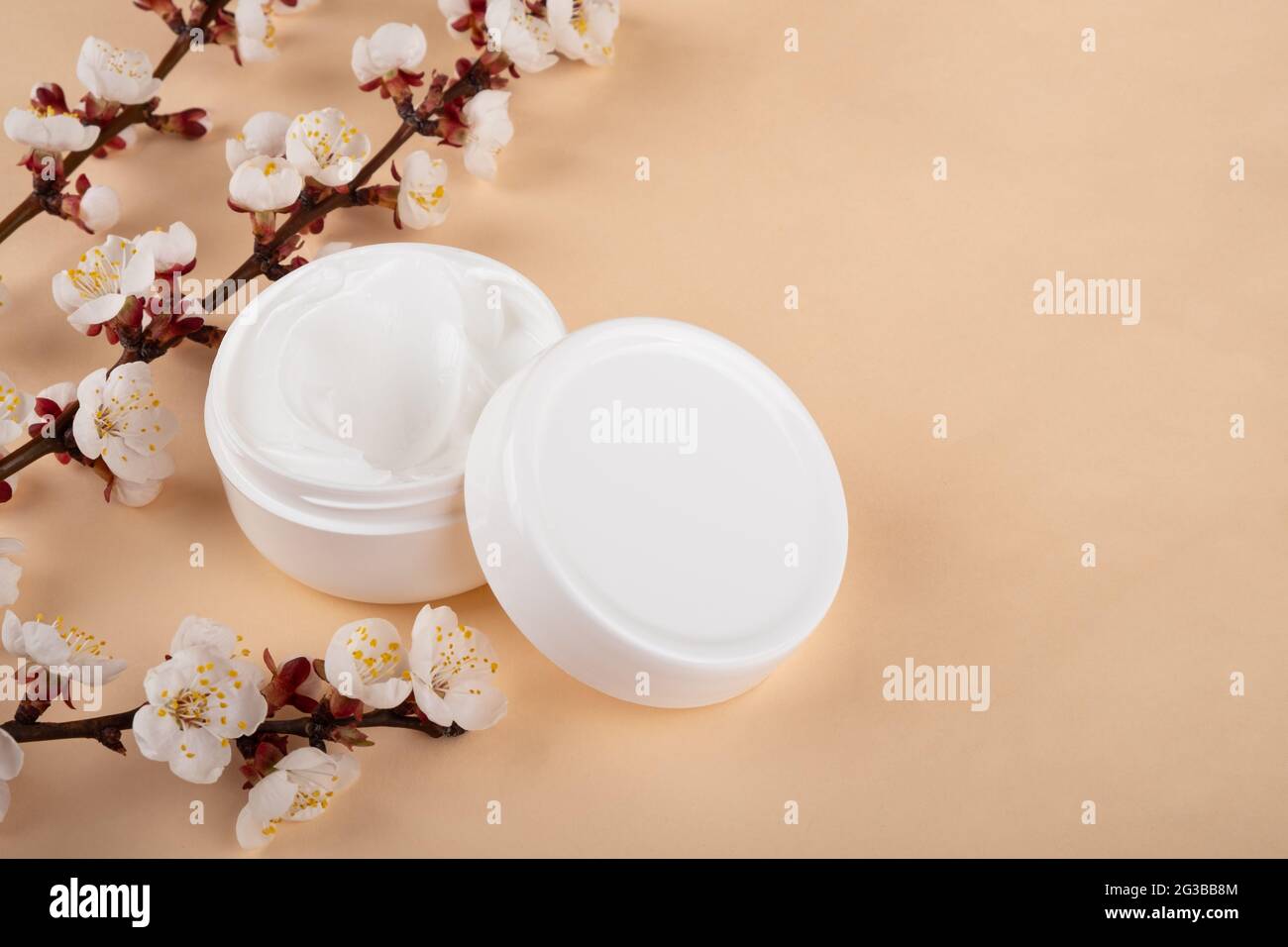 spring flower and cream on beige background. skin care Stock Photo - Alamy