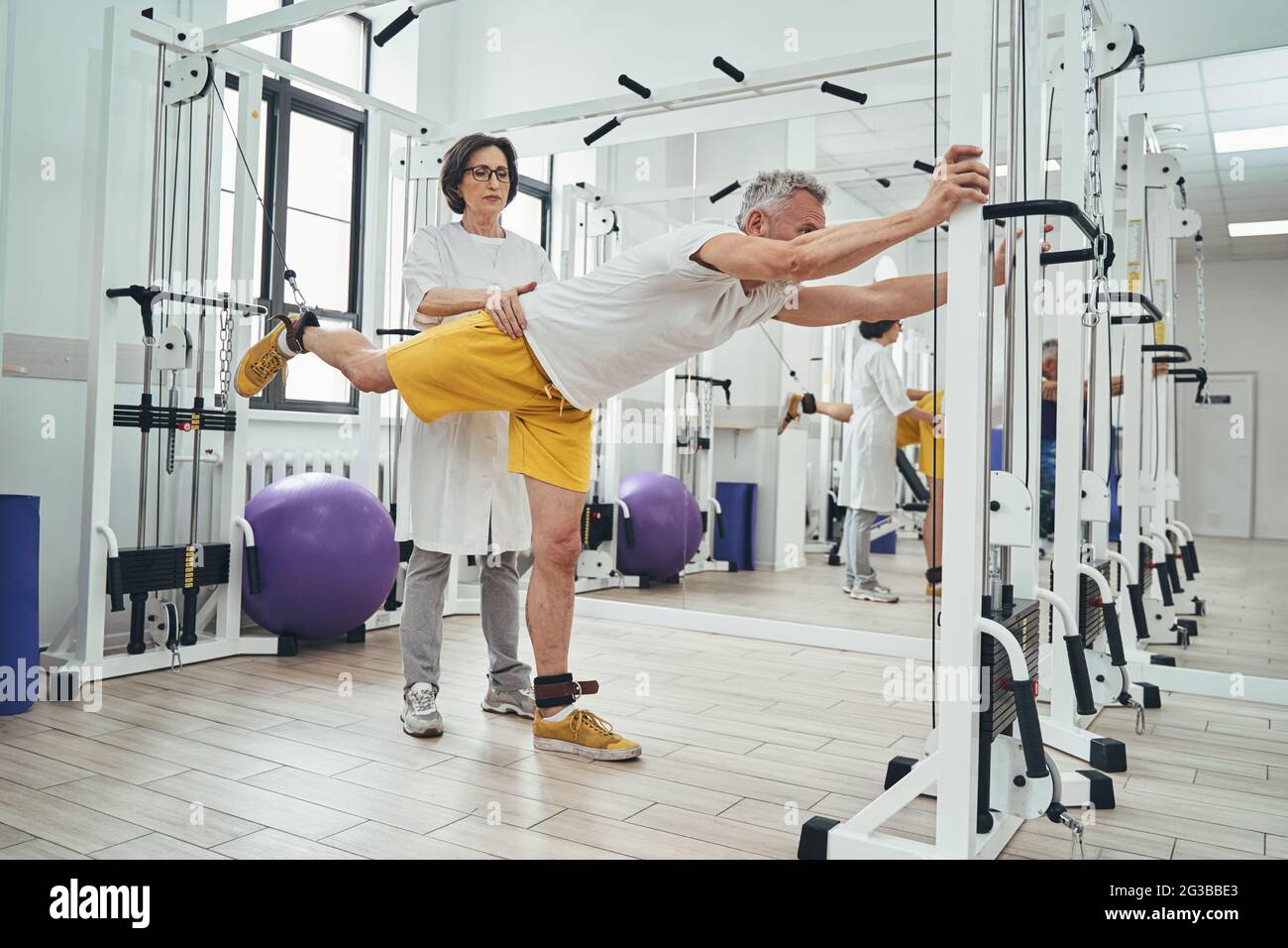 Patient performing a strength training exercise supervised by a ...