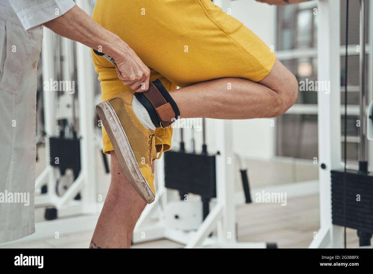 Athlete performing an exercise assisted by a rehabilitation physician ...