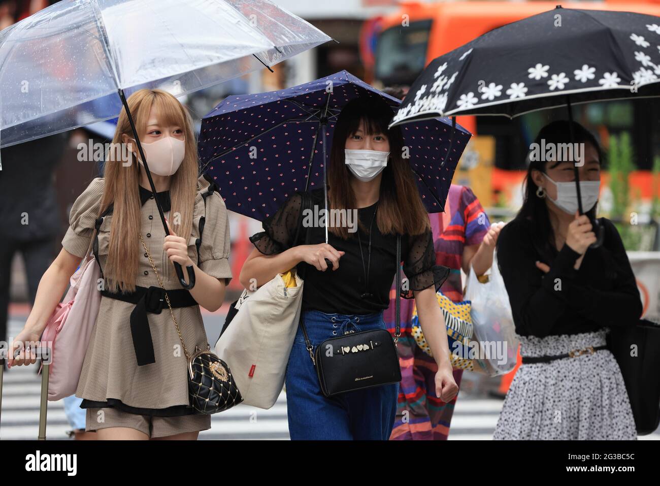 Women wearing face masks as a protective measure against Covid-19 hold ...