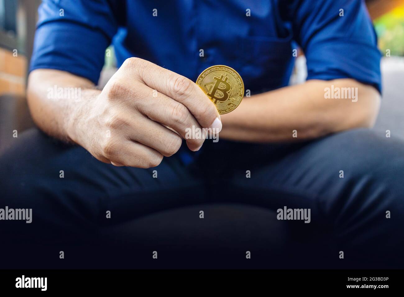 golden bitcoin in a businessman hand in the office with soft-focus and ...