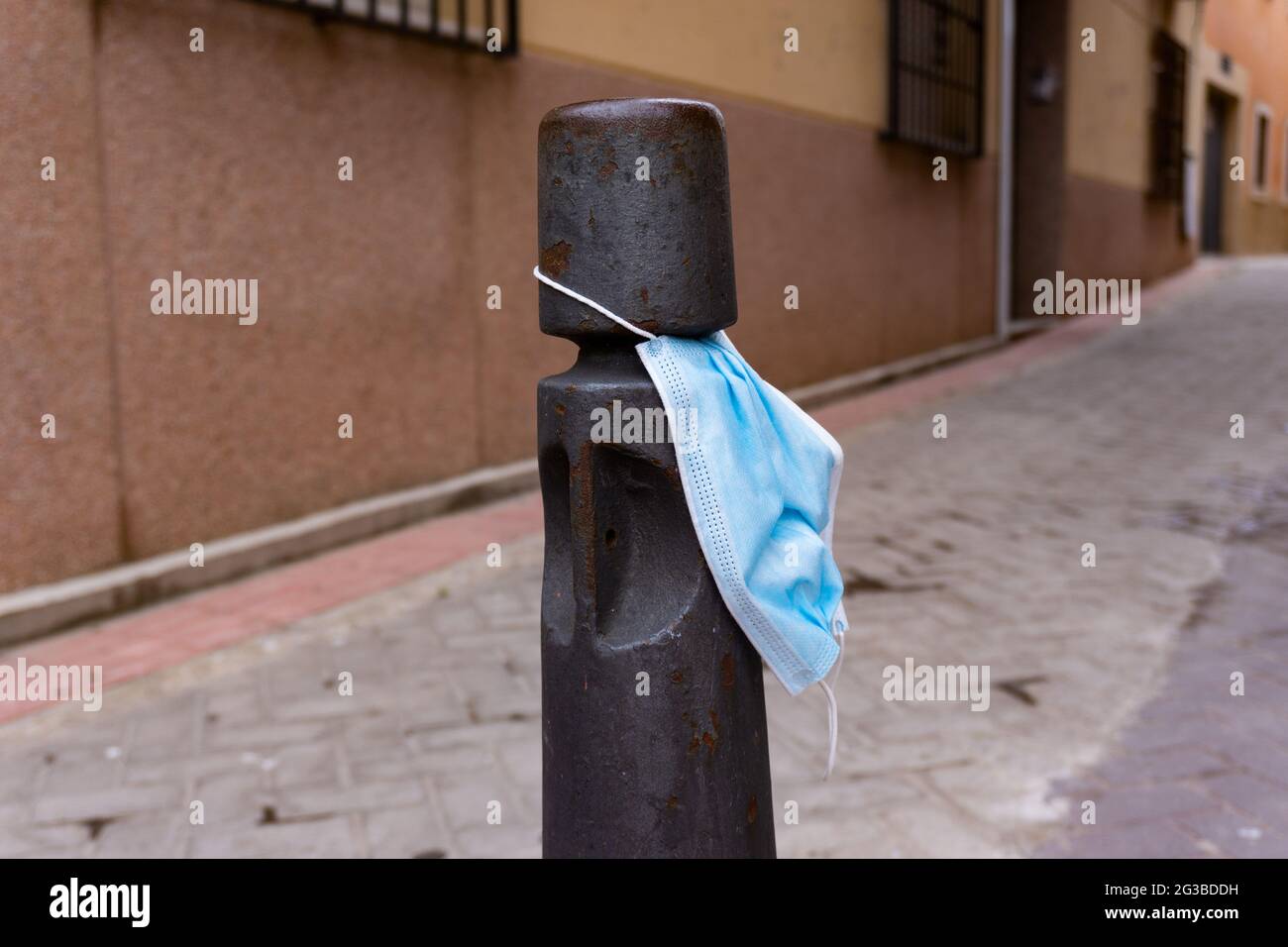 Closeup of a surgical mask hanging on a pole in the street Stock Photo ...