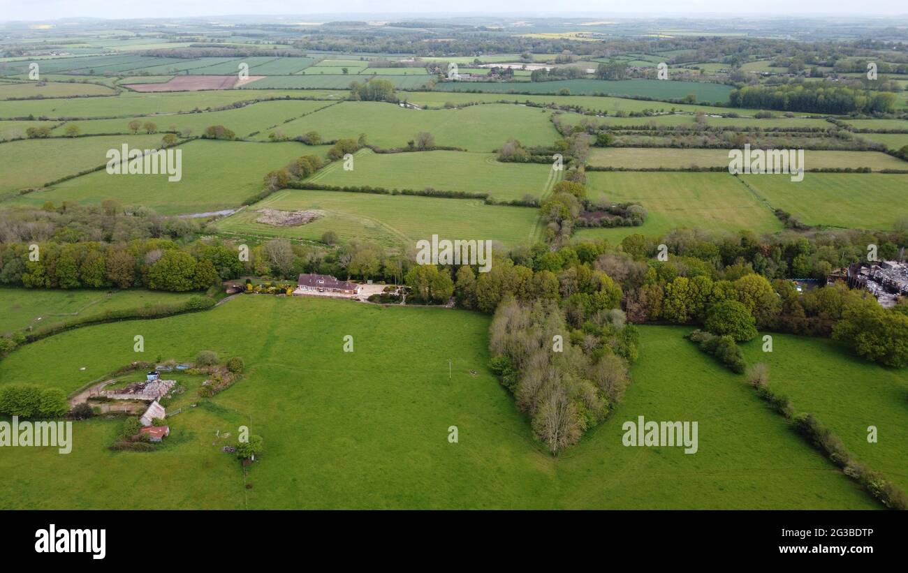 An aerial view over open countryside with hedgerows and rolling fields ...