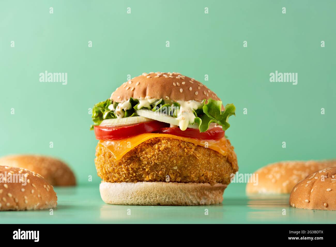 Crispy chicken burger on green background Stock Photo - Alamy