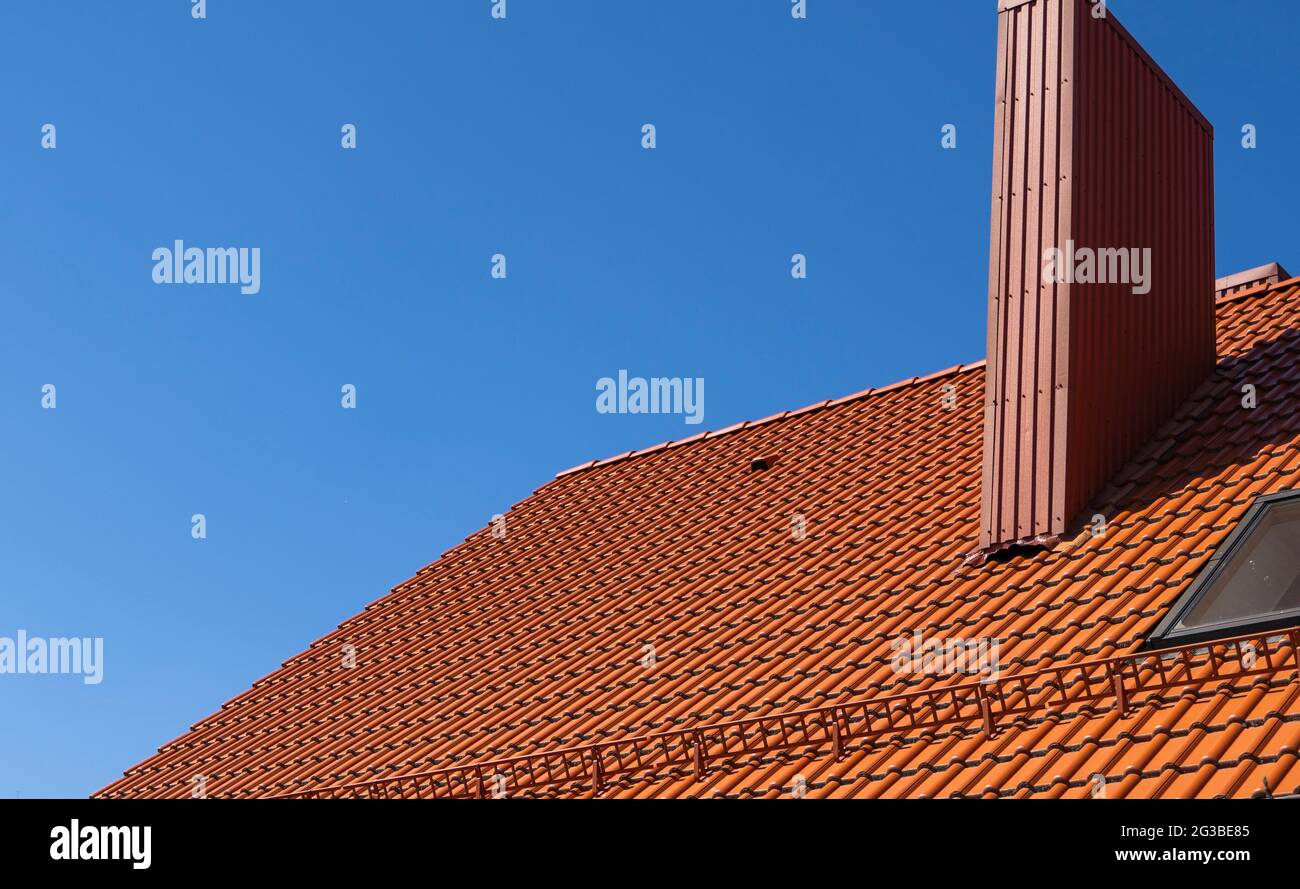 Red corrugated metal profile roof installed on a modern house. The roof ...