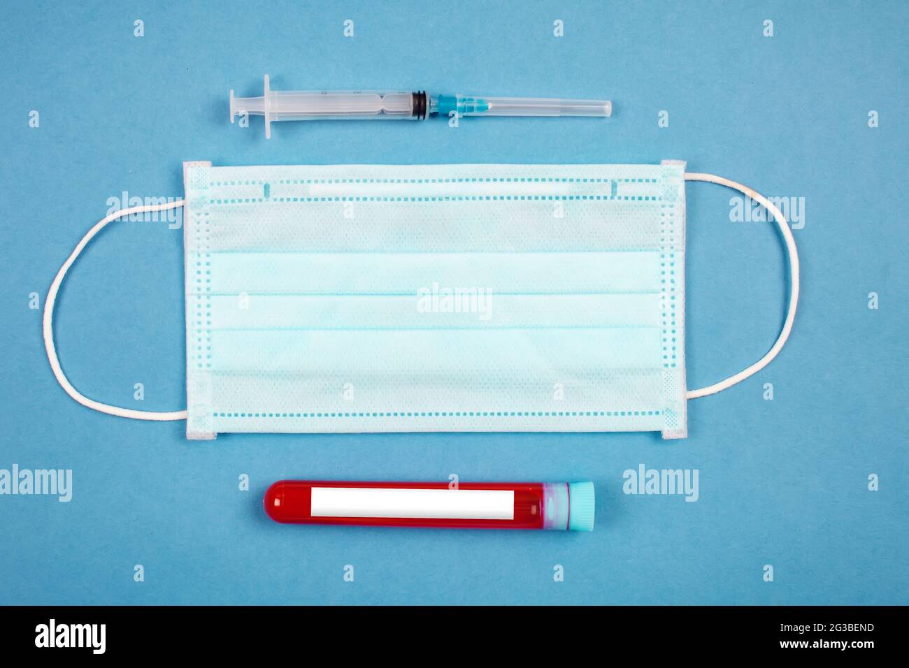 Medical mask and test tube with blood on a blue background. Healthcare ...